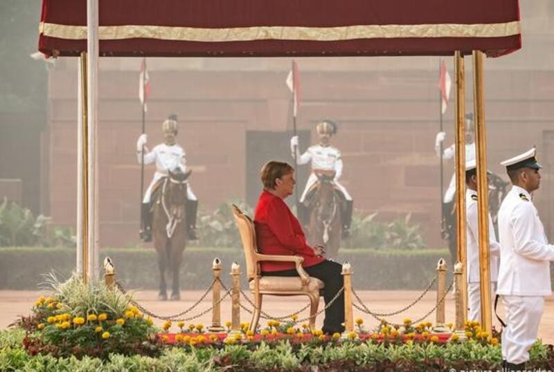 Why was Merkel sitting during national anthems at Rashtrapati Bhavan?